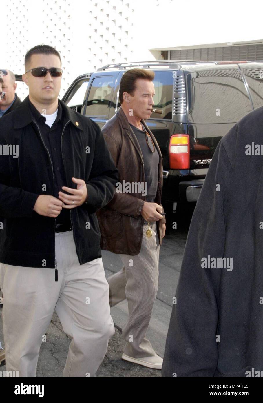 California Governor Arnold Schwarzenegger smokes a cigar as he leaves a ...