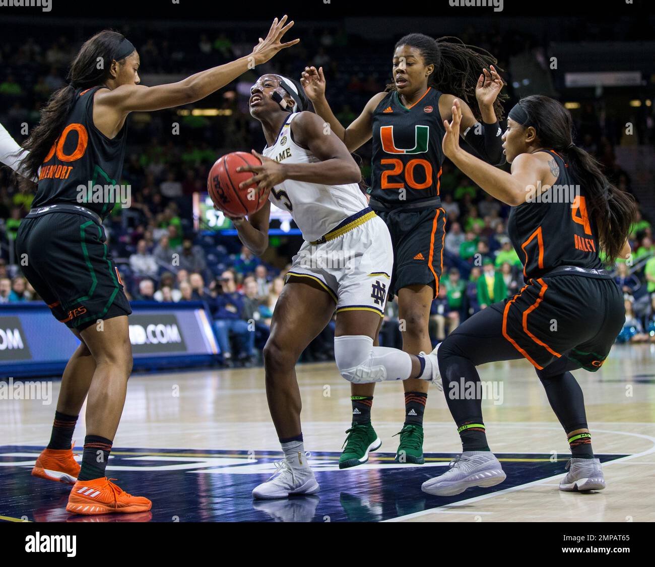 Notre Dame's Jackie Young (5) drives between Miami's Erykah Davenport ...