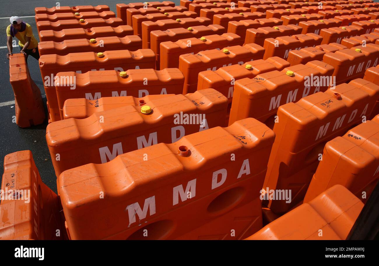 A Filipino worker arranges plastic barriers in Manila, Philippines on ...