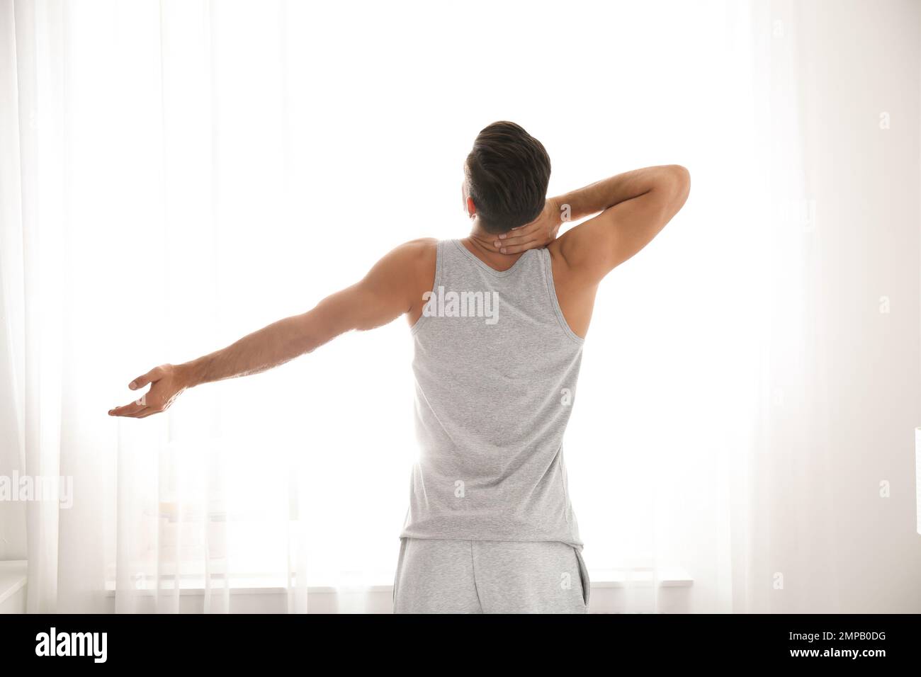 Man stretching near window at home. Lazy morning Stock Photo - Alamy