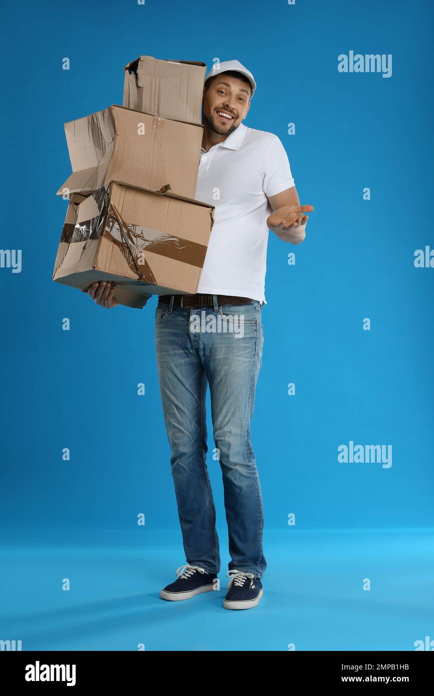 Emotional courier with damaged cardboard boxes on blue background. Poor ...