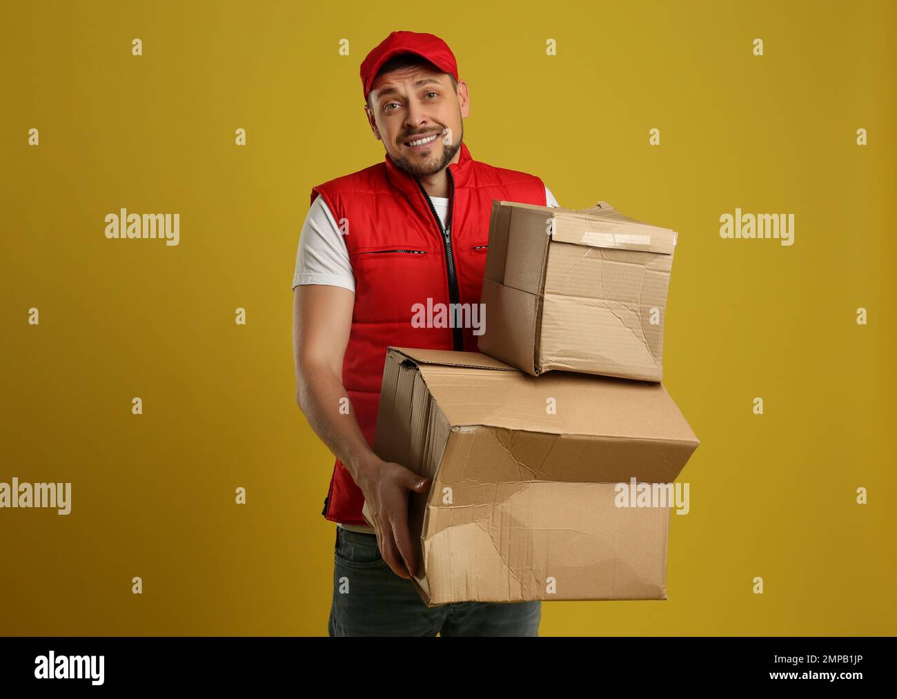 Courier with damaged cardboard boxes on yellow background. Poor quality ...
