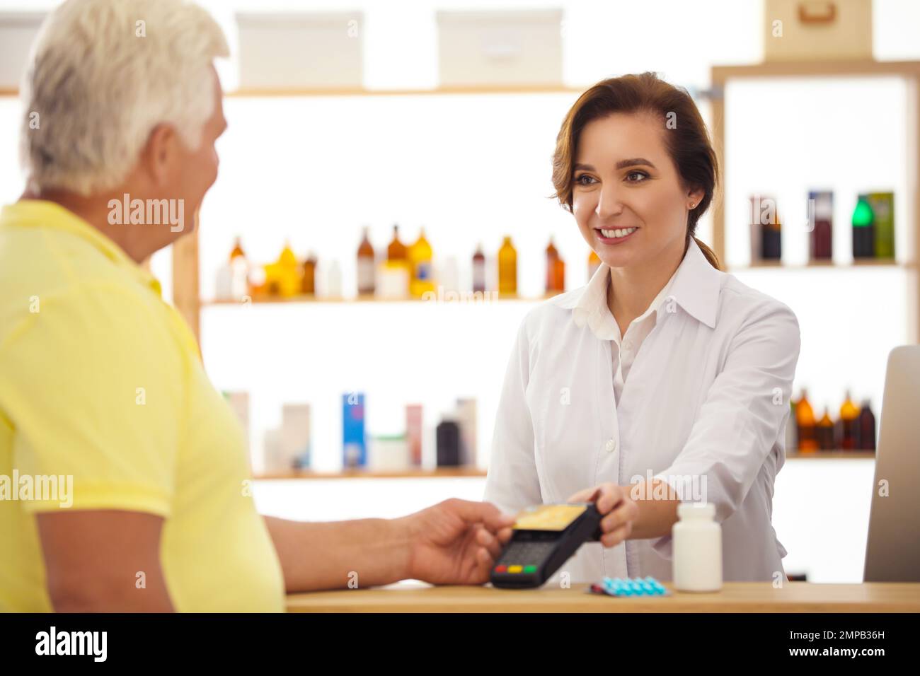 Customer using terminal for contactless payment with credit card in ...