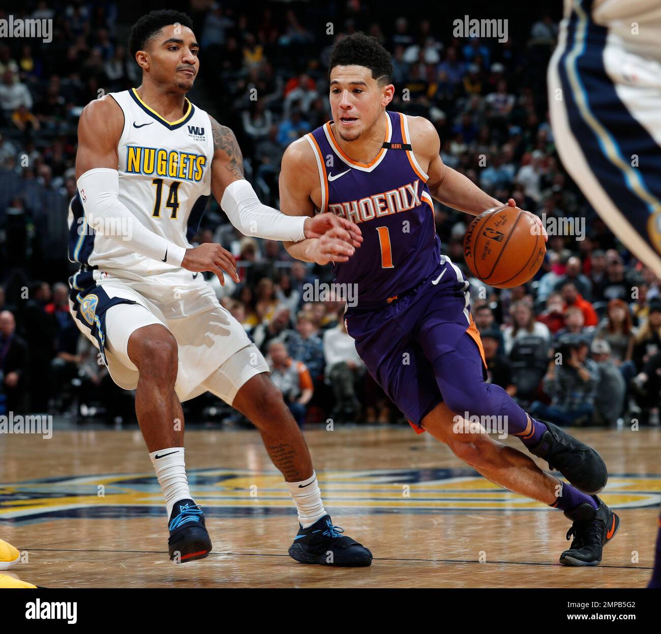 Phoenix Suns guard Devin Booker, right, drives against Denver Nuggets ...