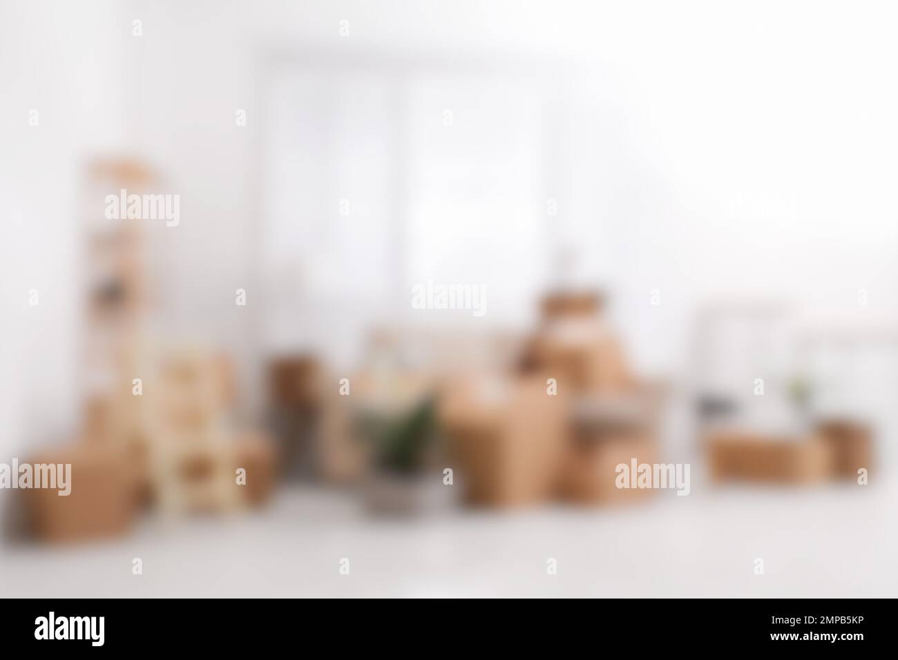 Blurred view of room with cardboard boxes. Moving day Stock Photo - Alamy