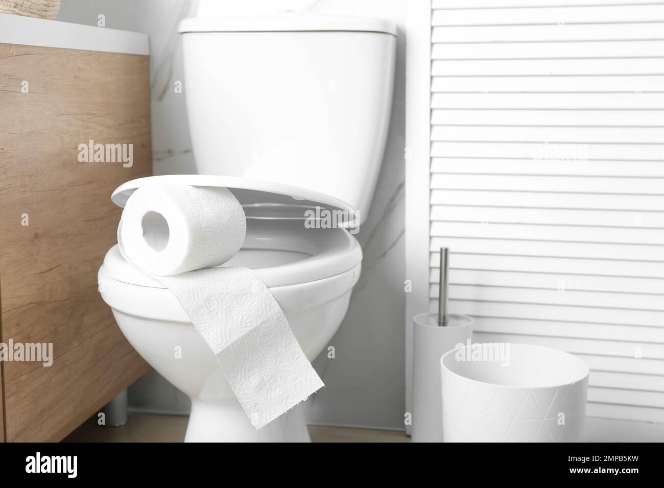 New paper roll on toilet seat in bathroom Stock Photo - Alamy