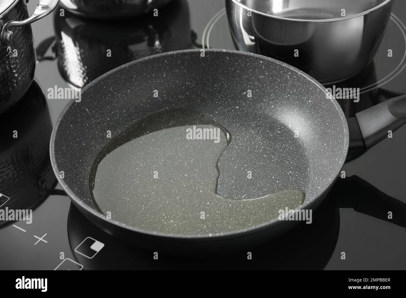 Frying pan with cooking oil on induction stove Stock Photo - Alamy