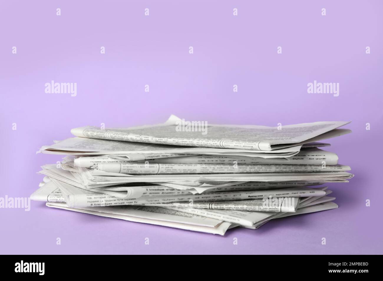 Stack of newspapers on light violet background. Journalist's work Stock ...