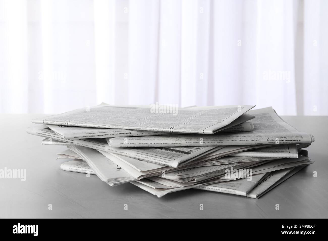 Pile of newspapers on grey table. Journalist's work Stock Photo - Alamy