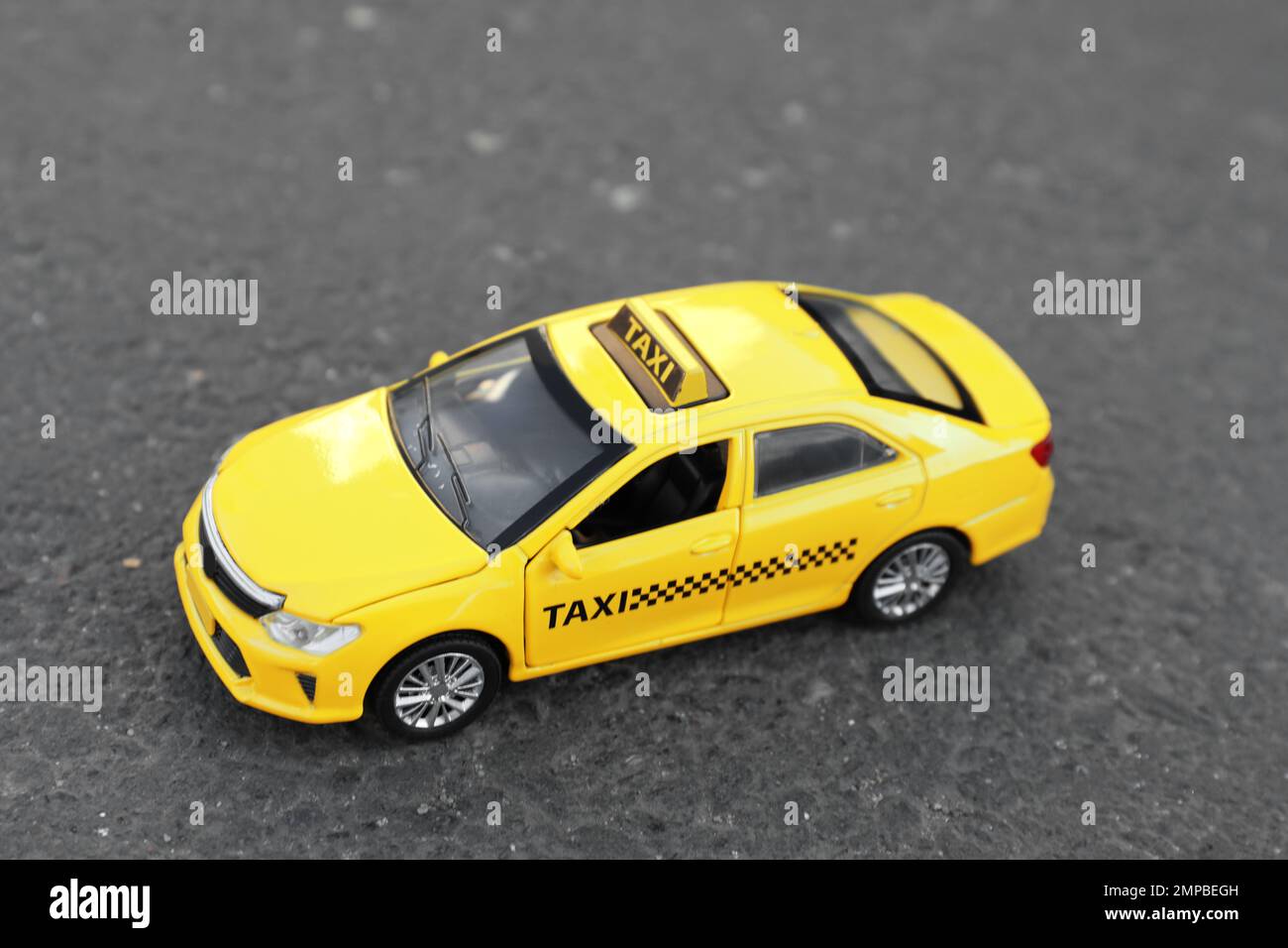 Yellow taxi car model on city street Stock Photo - Alamy