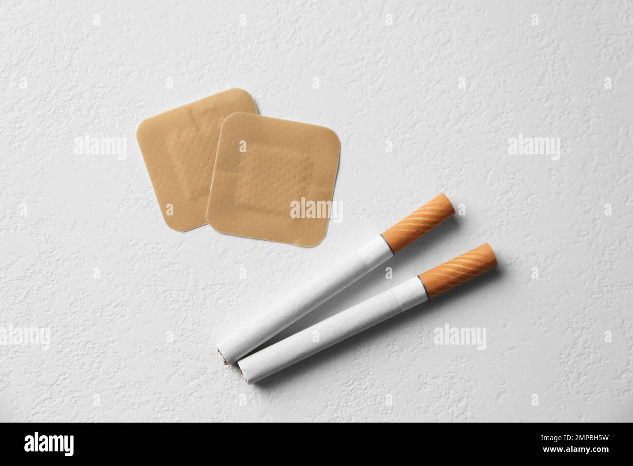 Nicotine patches and cigarettes on white background, flat lay Stock ...