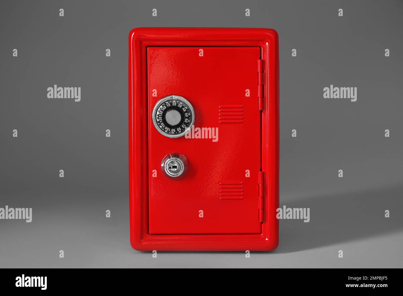 Closed red steel safe on light grey background Stock Photo - Alamy