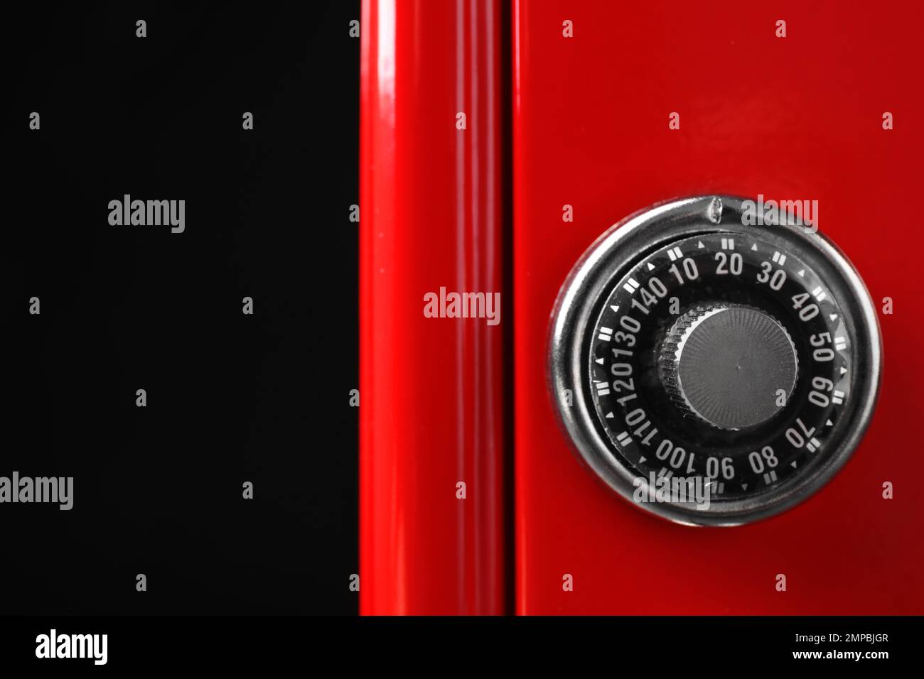 Red steel safe with mechanical combination lock on black background ...