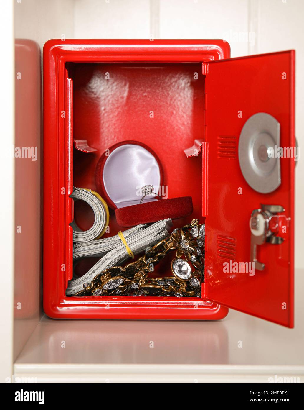Open red steel safe with money and jewelry on shelf Stock Photo - Alamy
