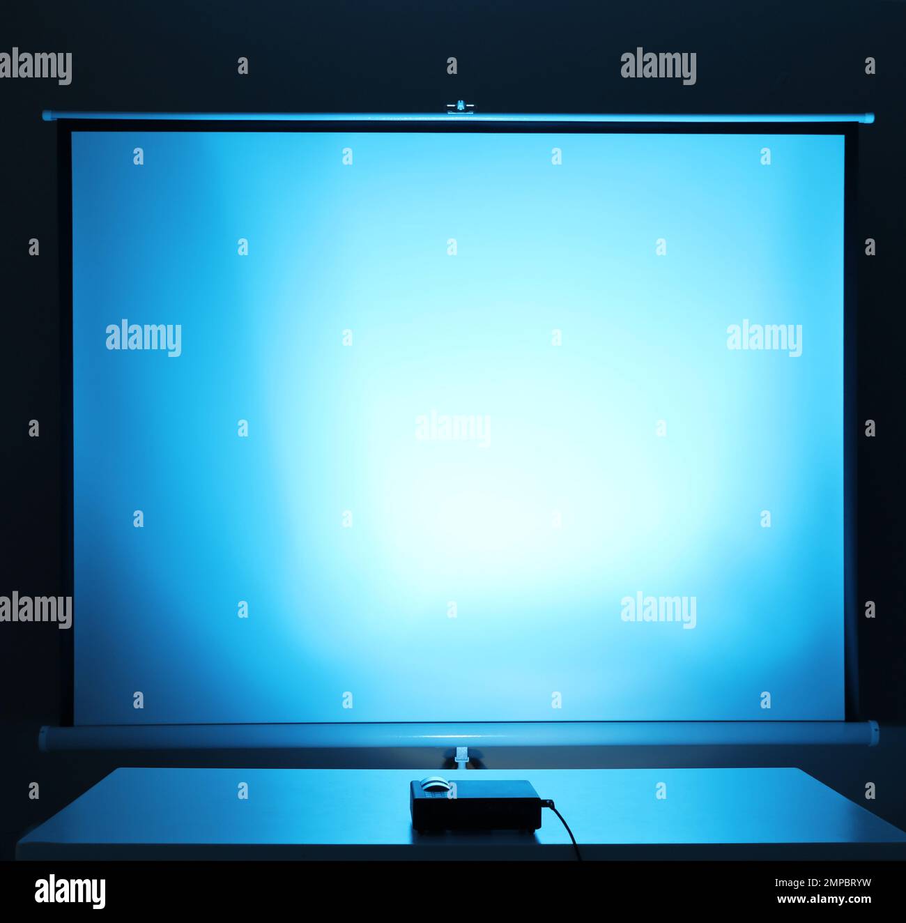 Video projector and screen indoors, toned in light blue. Space for ...