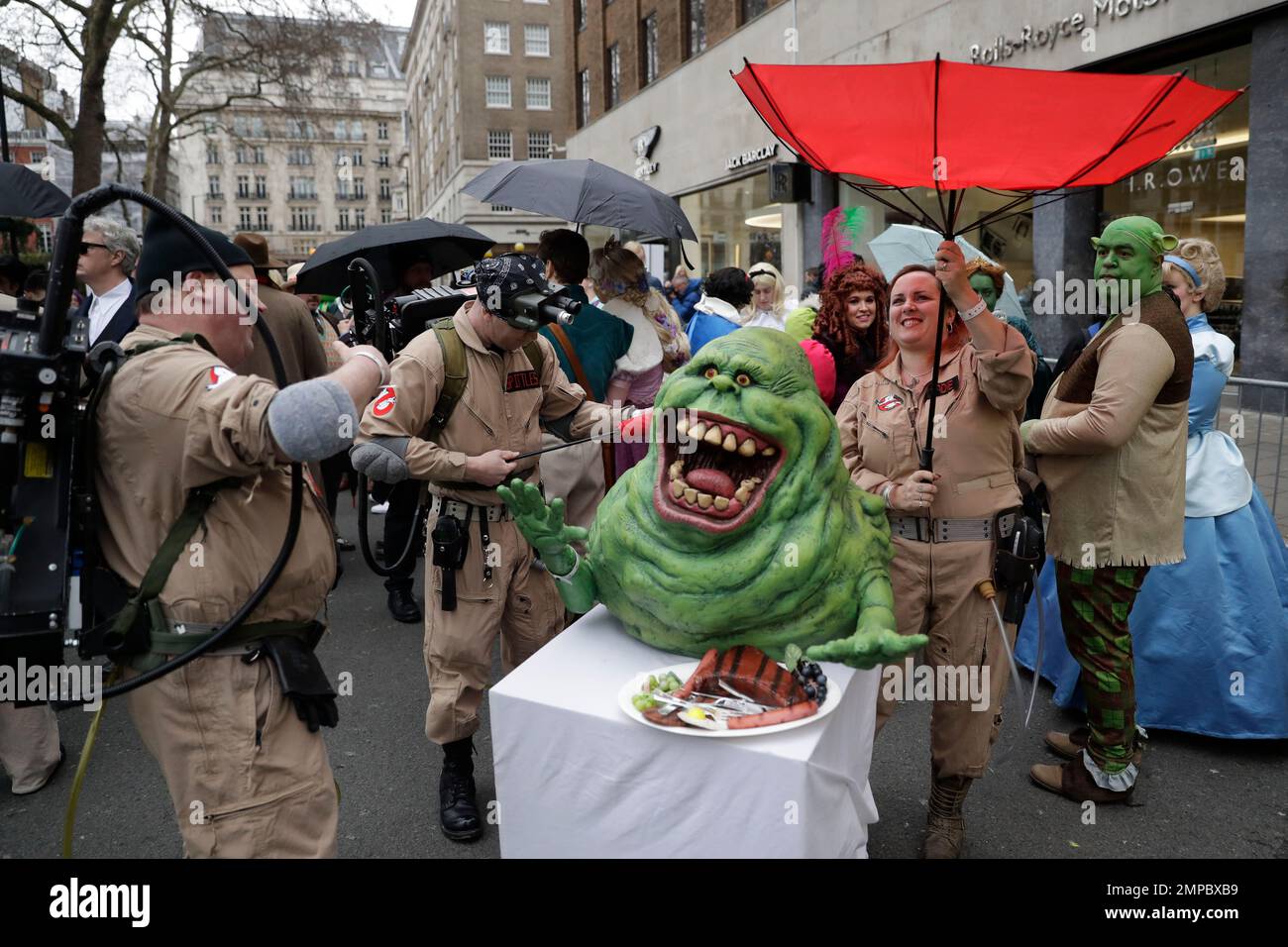 The wind blows an umbrella inside out as costumed participants as ...