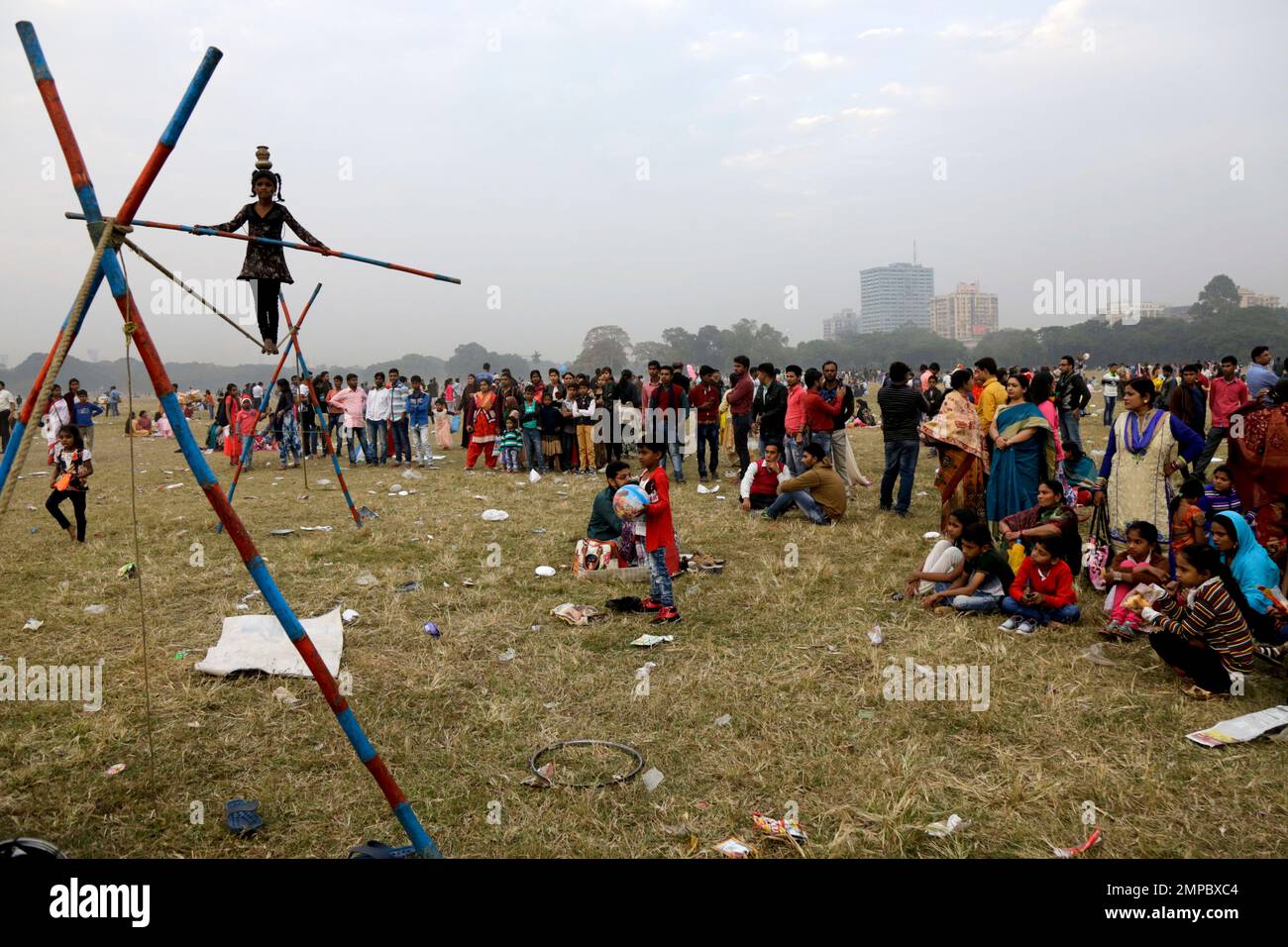 An Indian girl displays her tight rope walking skills to attract alms ...