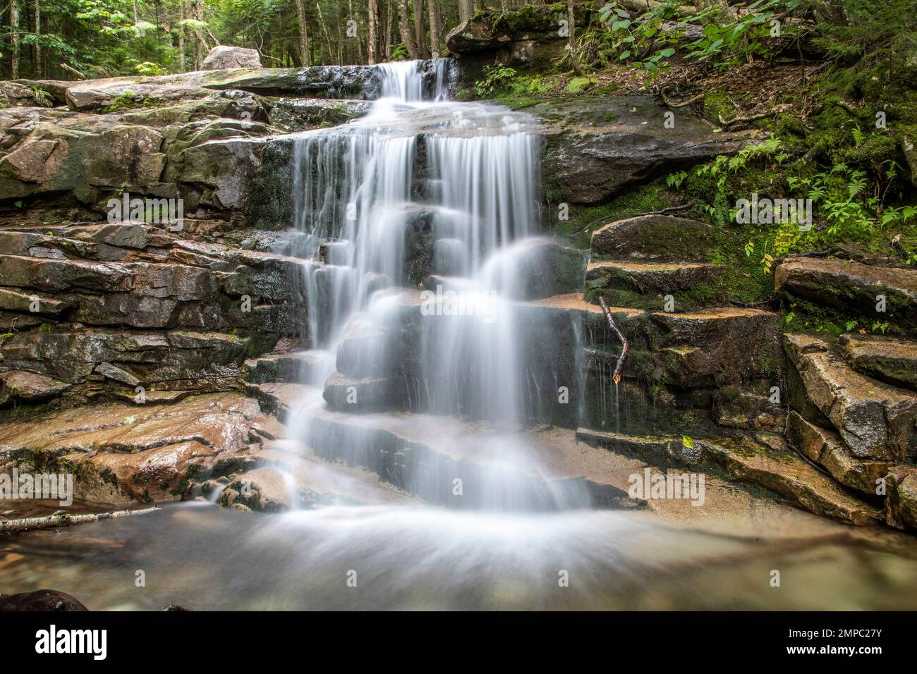 A breathtaking view of foamy waterfall flowing through rocks in the ...