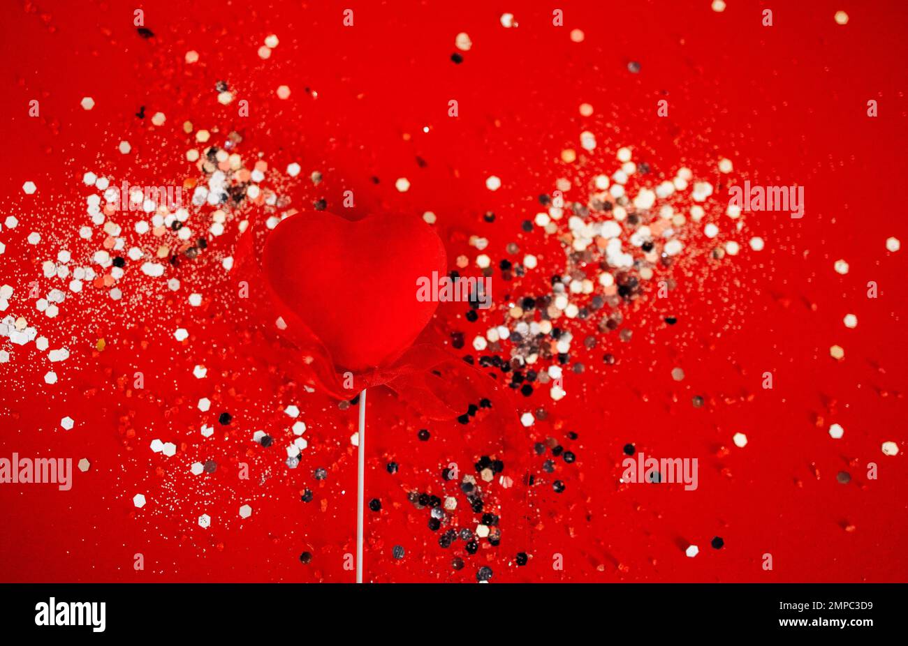 Decorative heart on a stick with ribbon. Bright background with silver ...