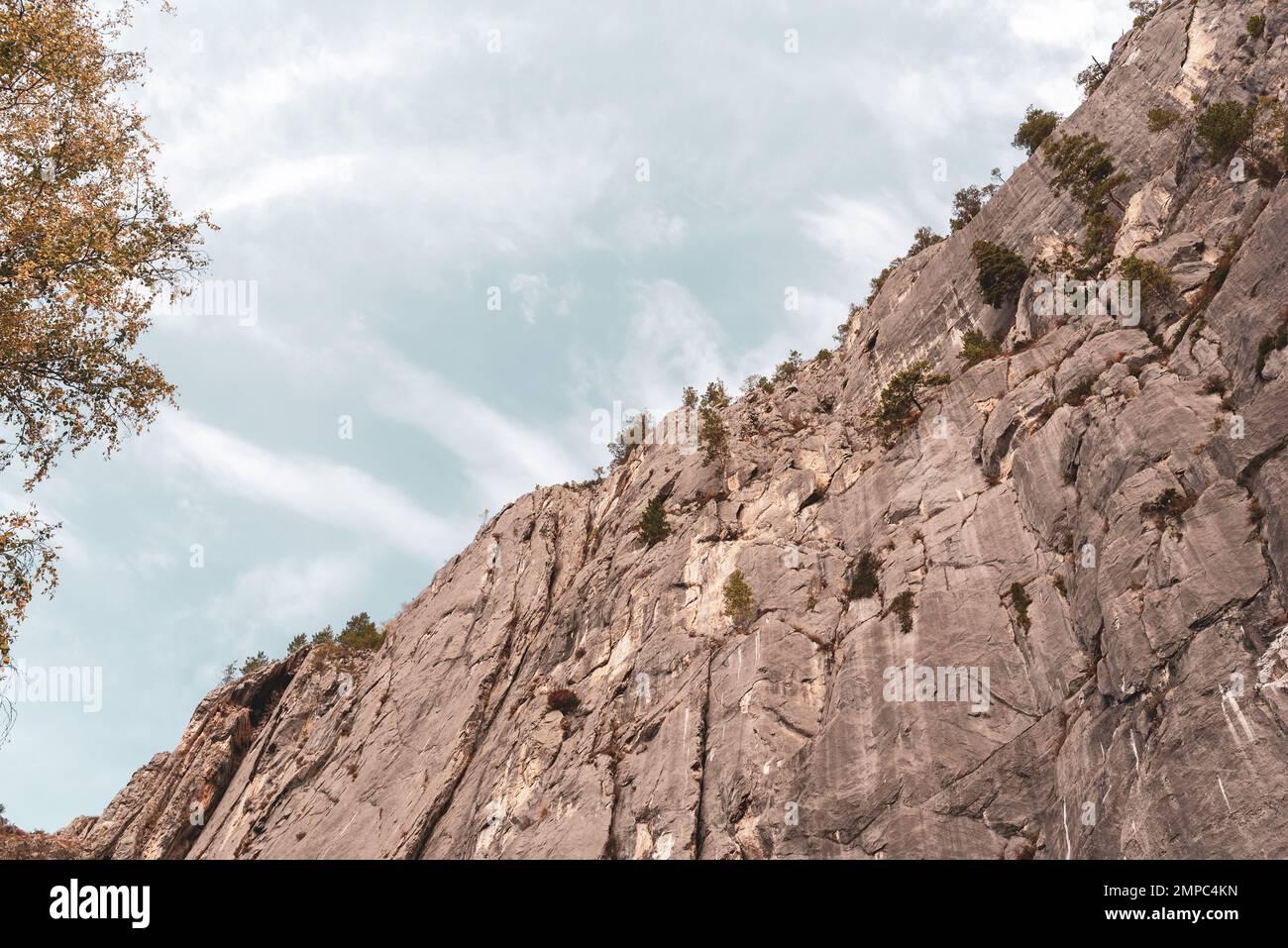 The high stone wall of the mountain goes into the sky with clouds Stock ...