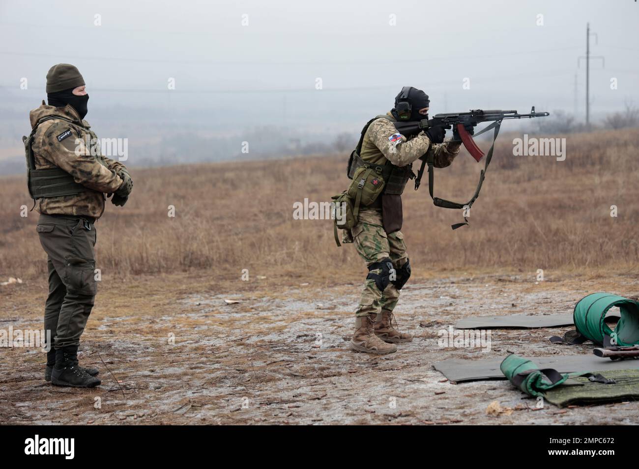 A Russian army soldier shoots as an instructor stands near during a ...