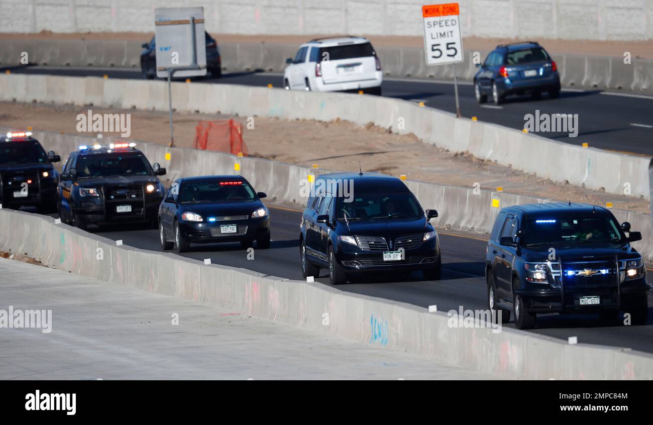 A hearse, second in the procession, carries the body a sheriff's deputy ...