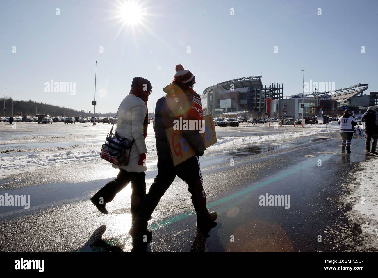 Fans arrive bundled against the cold weather in the parking lot of ...
