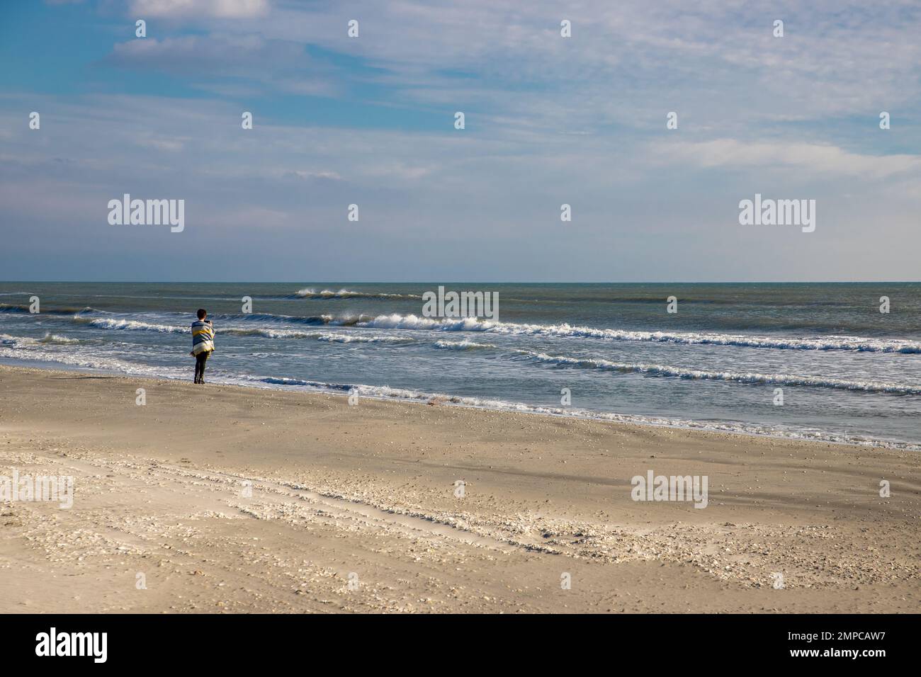 Landscape of a lonely woman walking on a beach in Corbu - Romania Stock ...