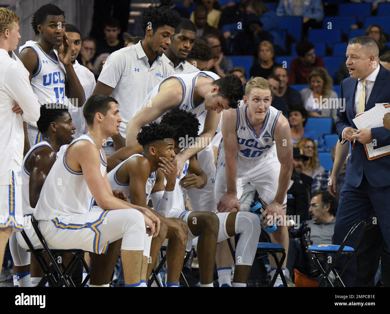 UCLA assistant coach David Grace, right, talks to UCLA players during a ...