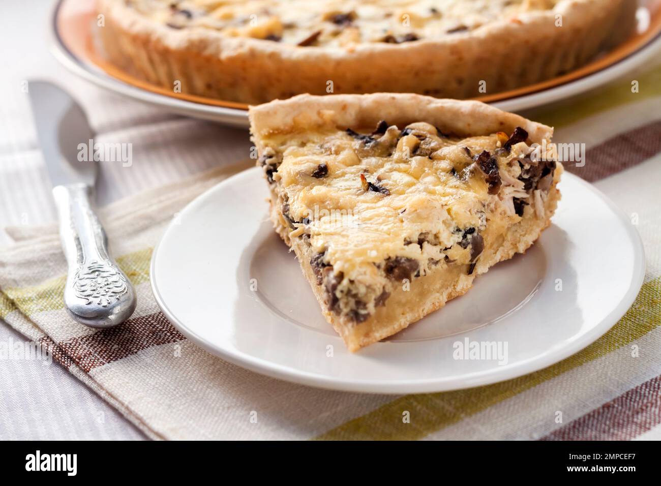 Slice of chicken tart with mushrooms and cheese on a plate Stock Photo ...