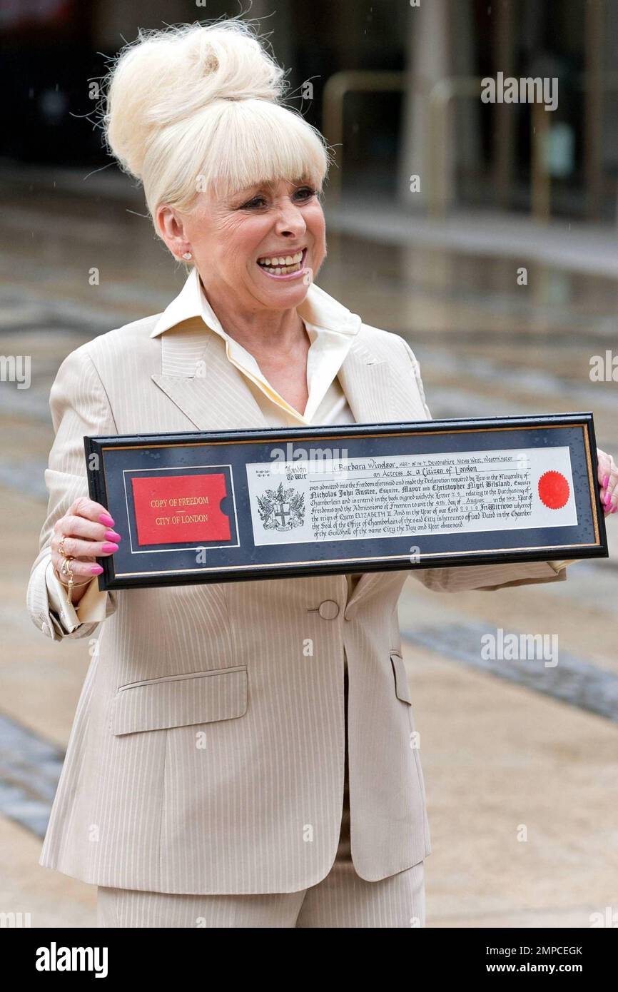 Actress Barbara Windsor braves the rain to show off her award after ...
