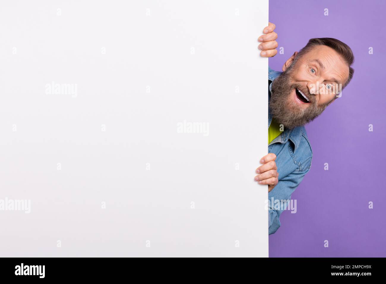 Photo portrait of nice retired man hide behind white empty space wall ...