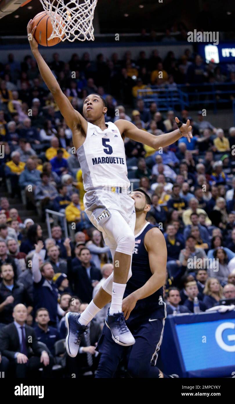 Marquette guard Greg Elliott, left goes up for a basket against Xavier ...