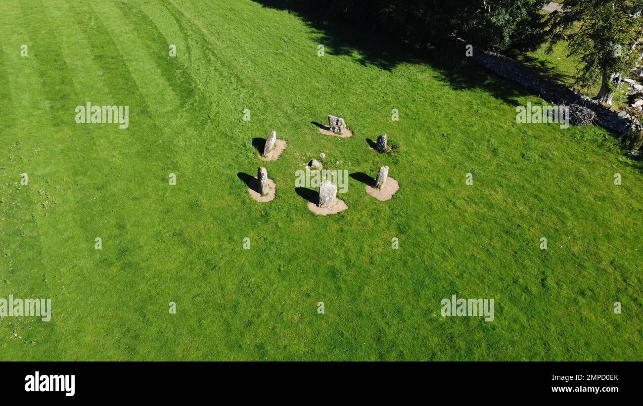 An aerial shot of cromlech stones in the green wide field under the ...