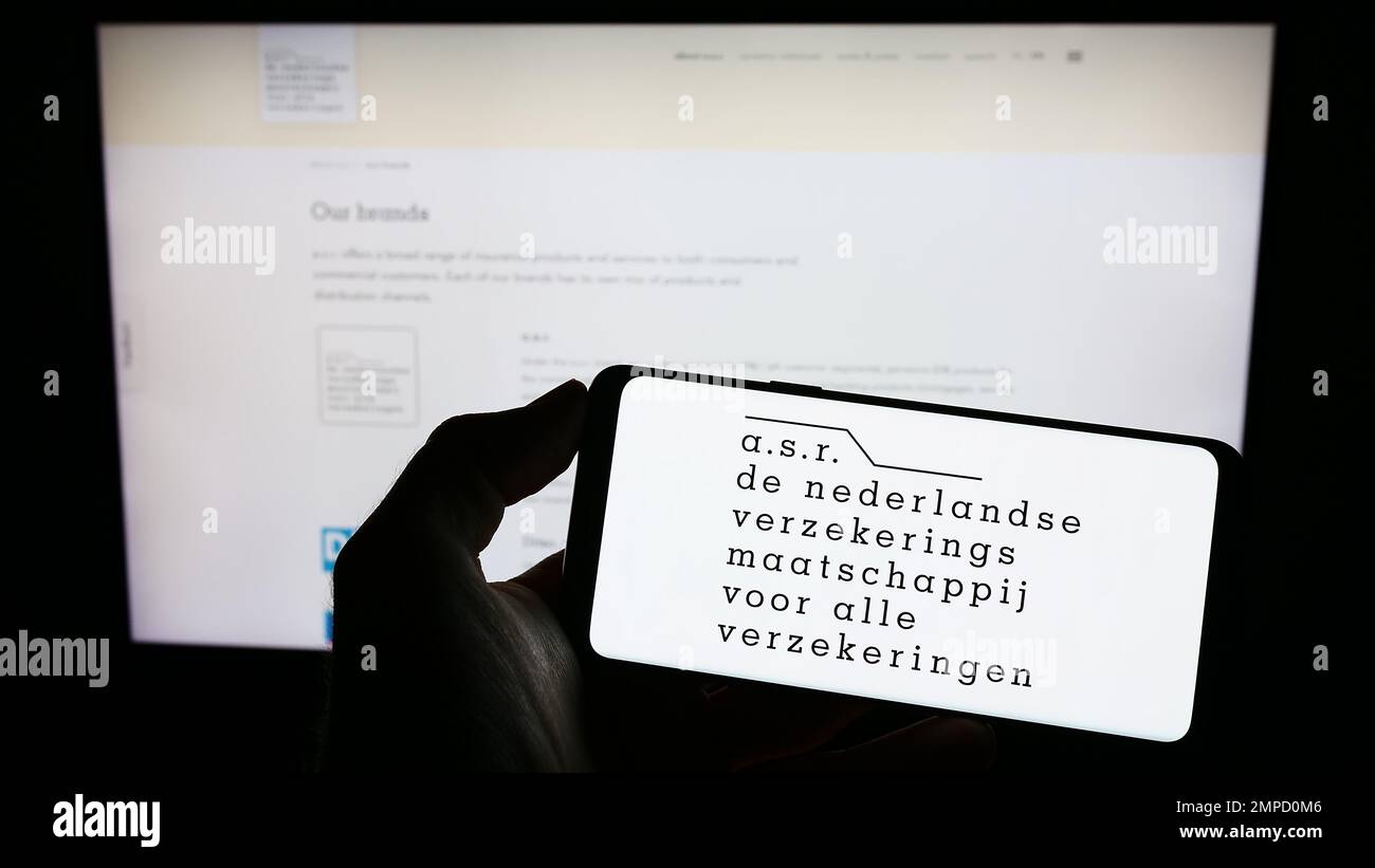 Person holding mobile phone with logo of Dutch insurance company ASR ...
