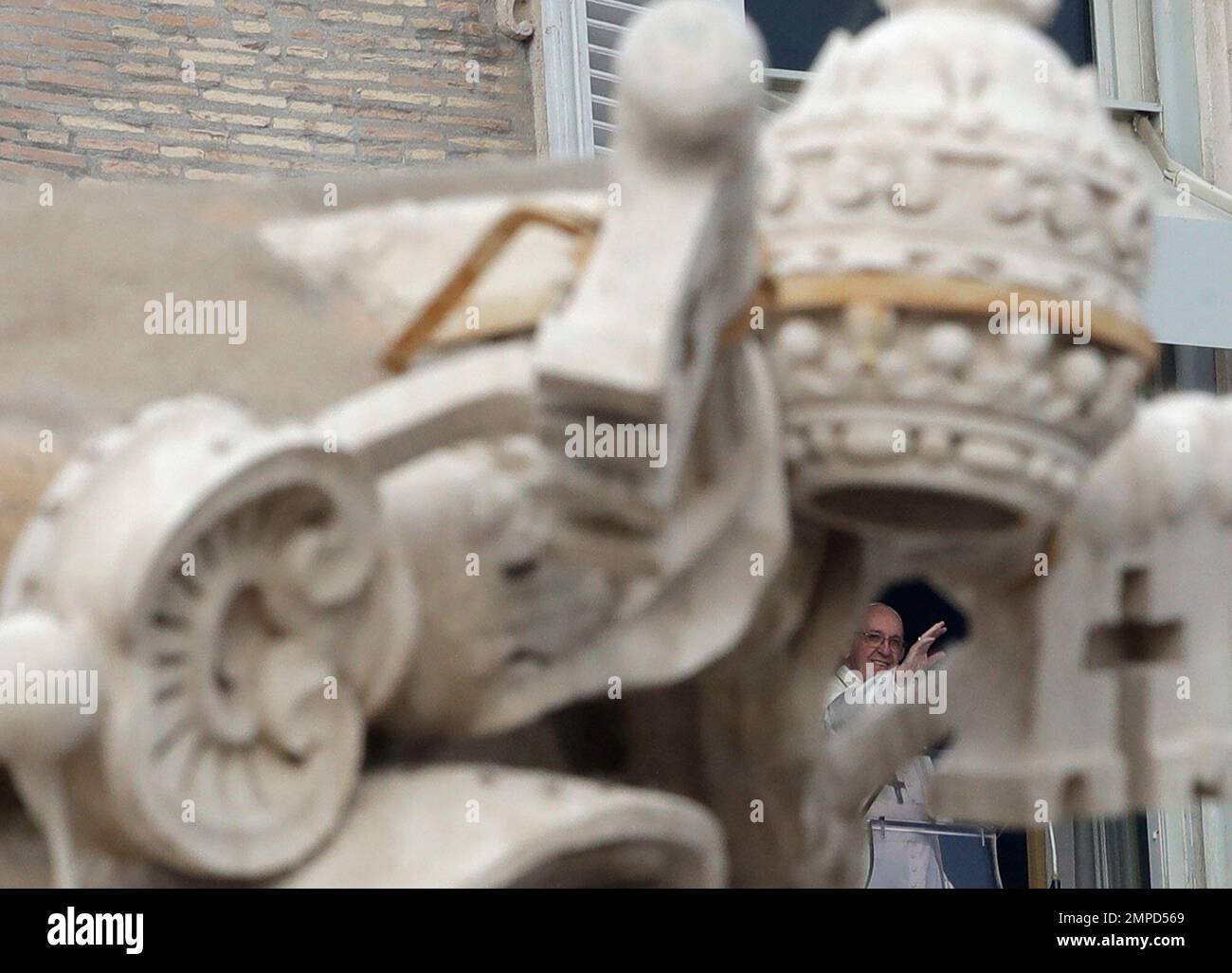 Pope Francis, seen through a marble statue, speaks to faithful gathered ...