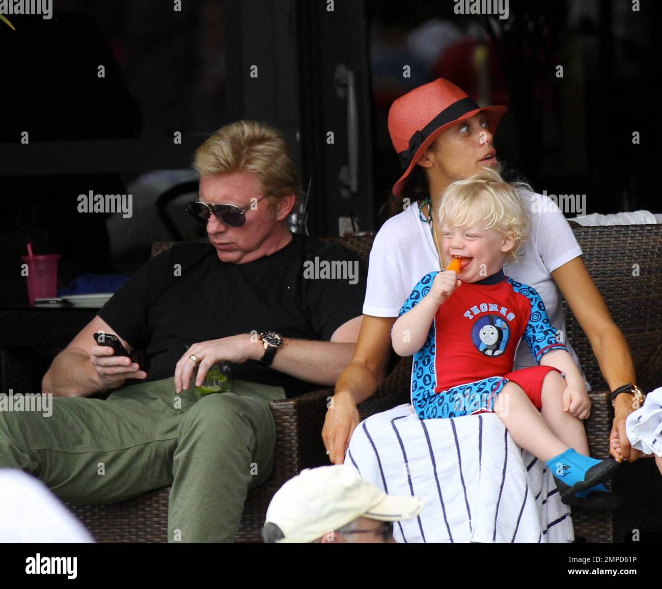 The Becker family lunch at a beachside hotel pool with pals. Boris and ...