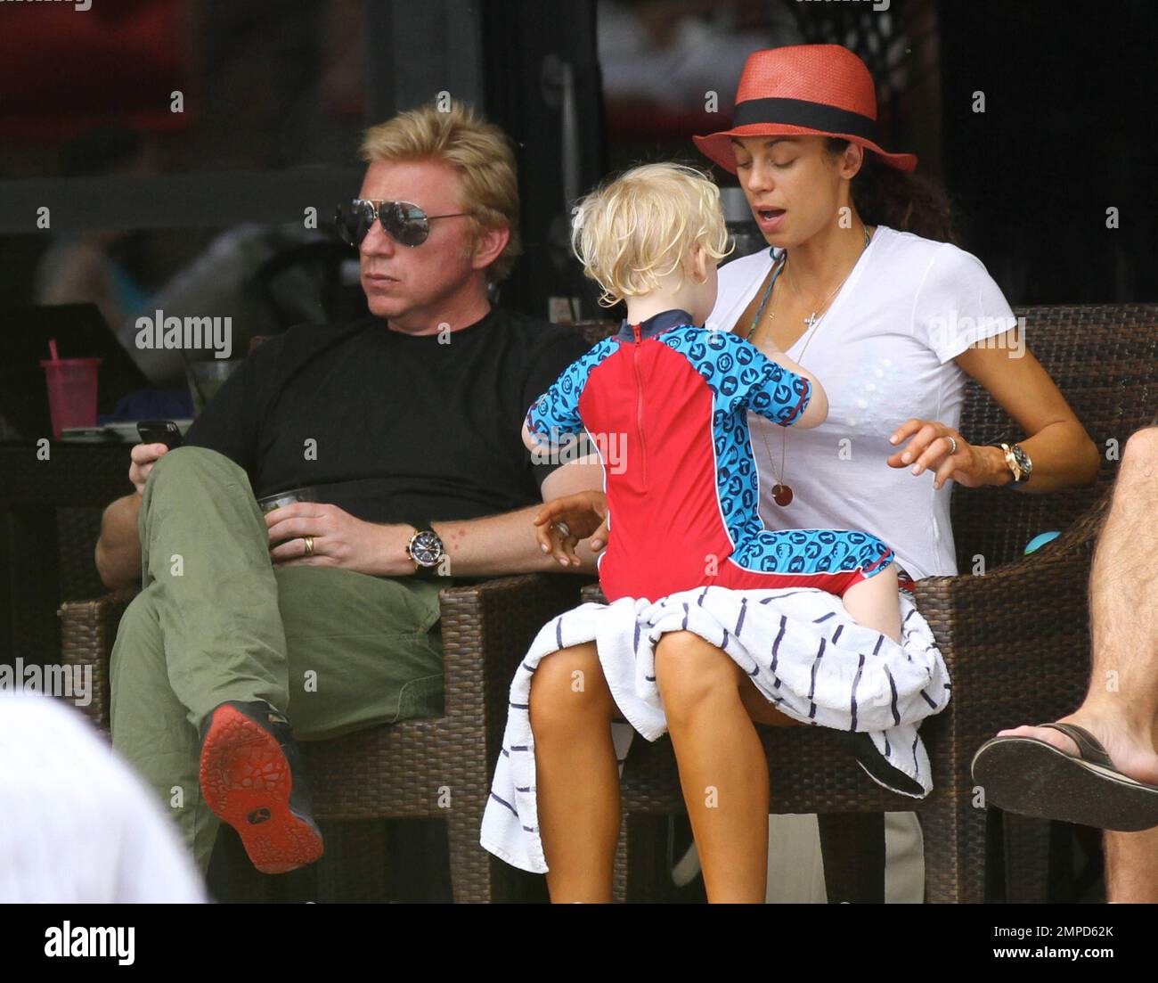 The Becker family lunch at a beachside hotel pool with pals. Boris and ...