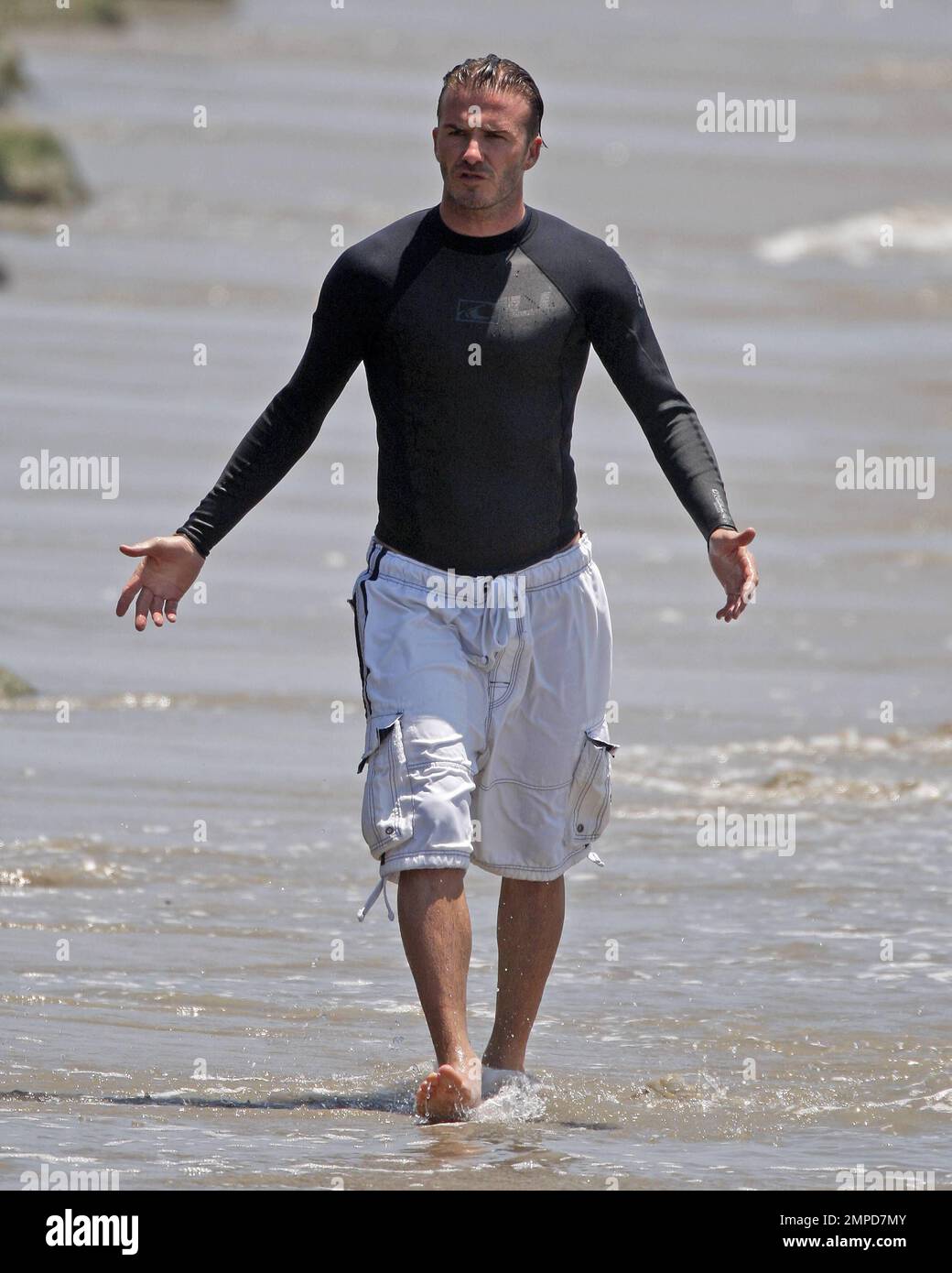 David Beckham and family wearing wet suit tops have fun boogie boarding ...