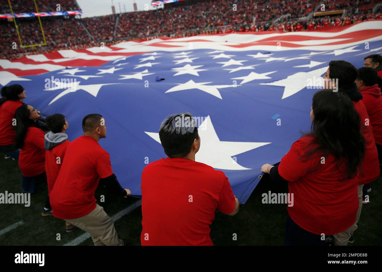 A large flag is presented during the performance of the national anthem ...