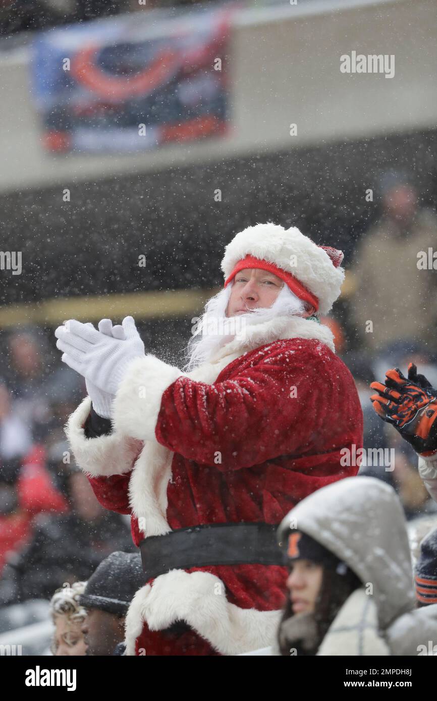 A fan wears a Santa Claus suit in the stands during an NFL football ...