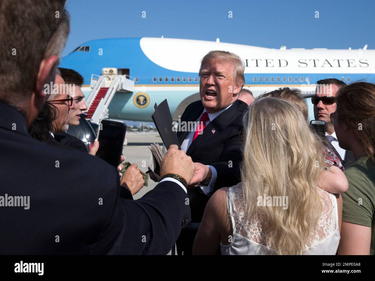 President Donald Trump greets people on the tarmac as he arrives on Air ...