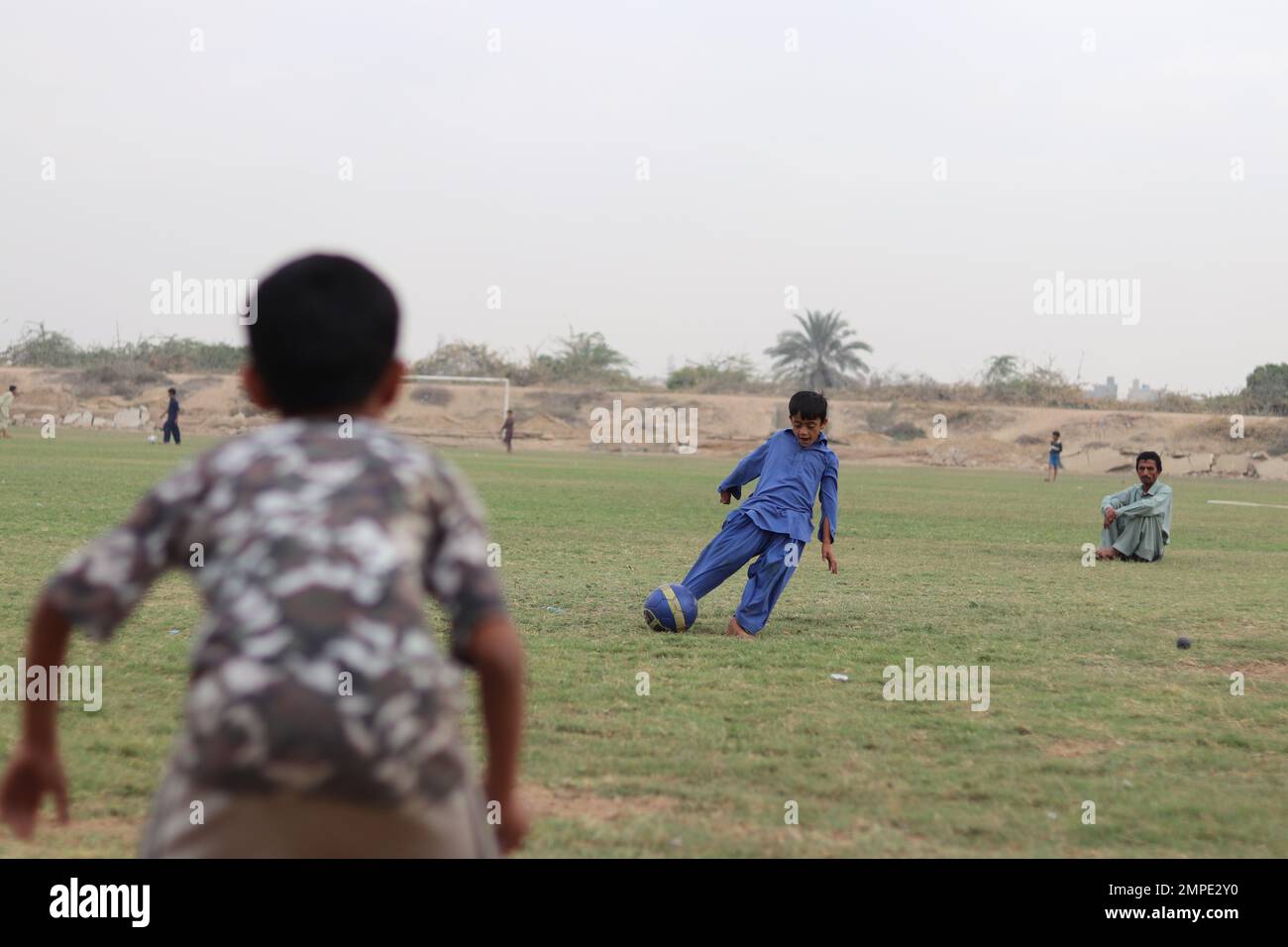 Karachi Pakistan 2019, a kid kicking a football on Sunday morning in ...