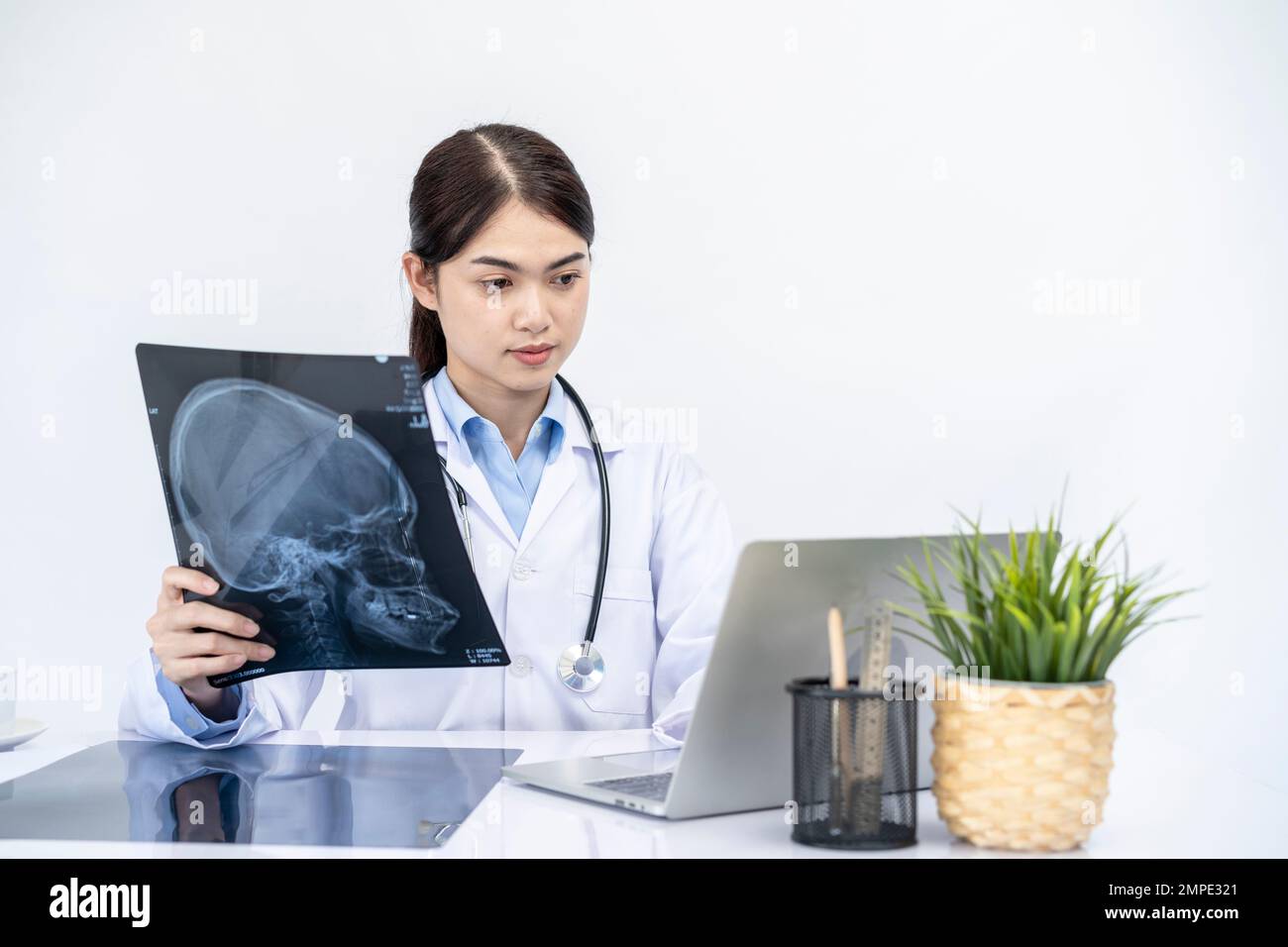 Female doctor check film x-ray image from machine. Analyze a progress ...