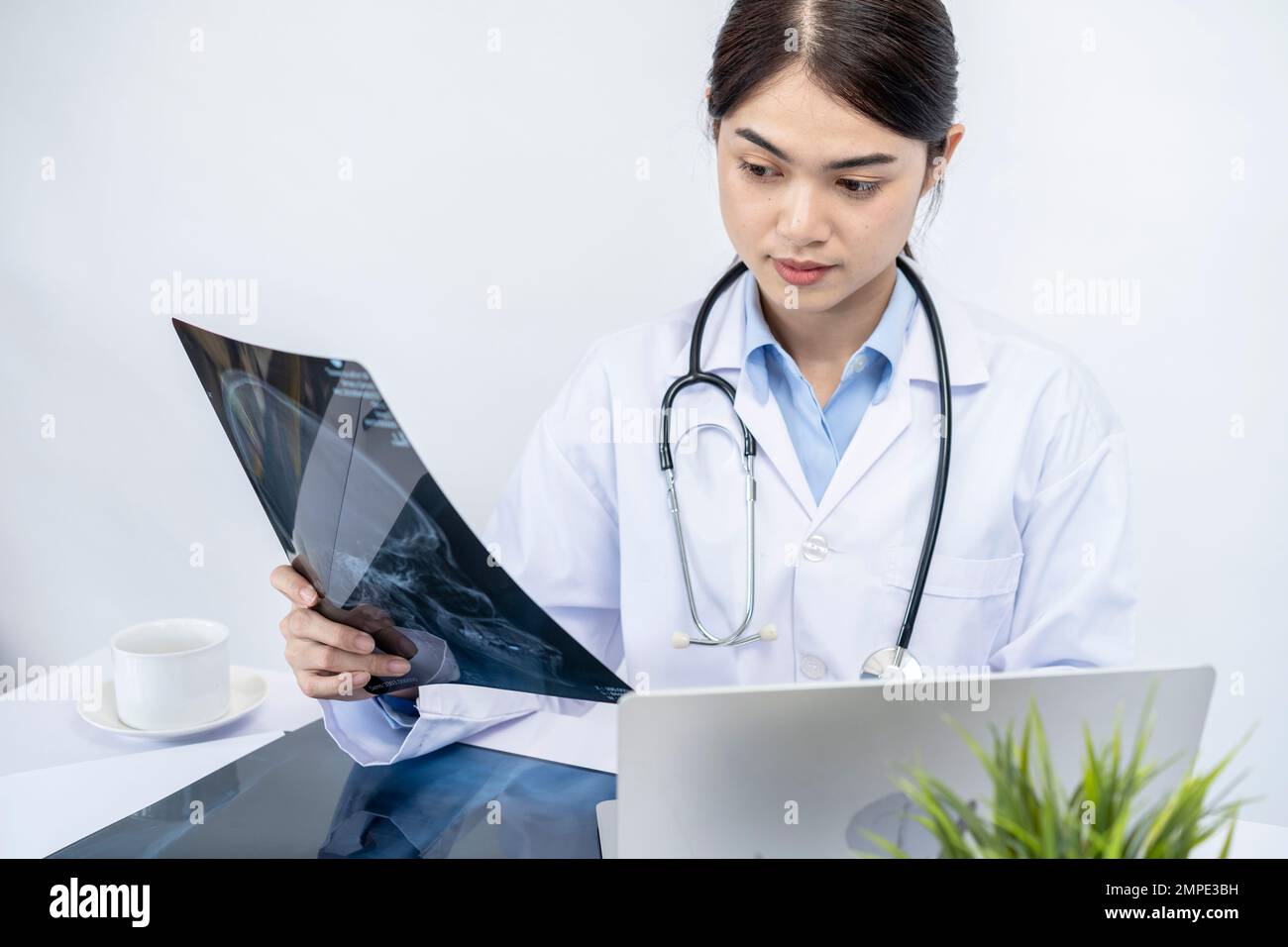 Female doctor check film x-ray image from machine. Analyze a progress ...