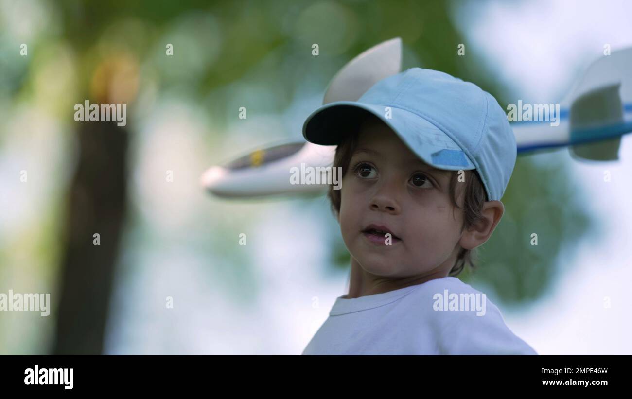 Cute small boy throwing plane glider outside at park. Happy child ...