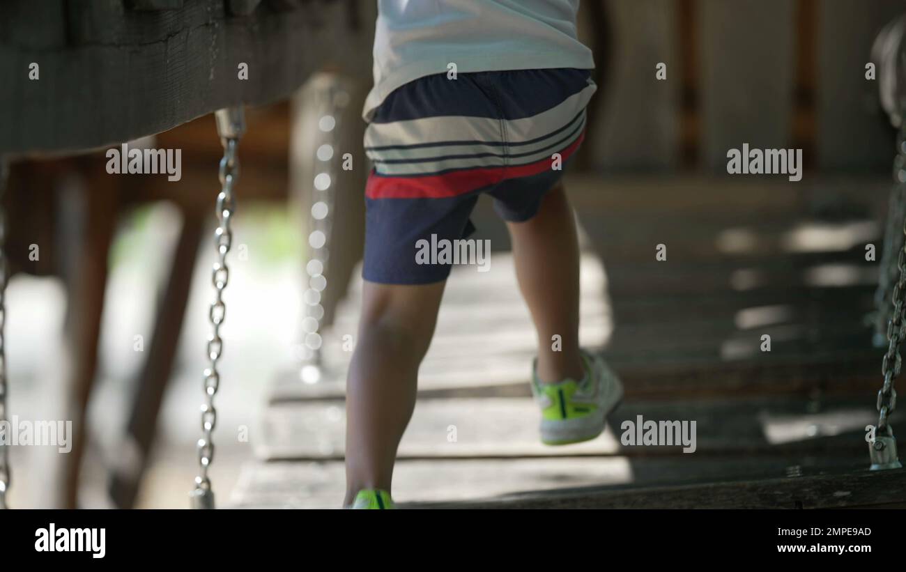 One active child running on playground structure. Kid having fun at ...