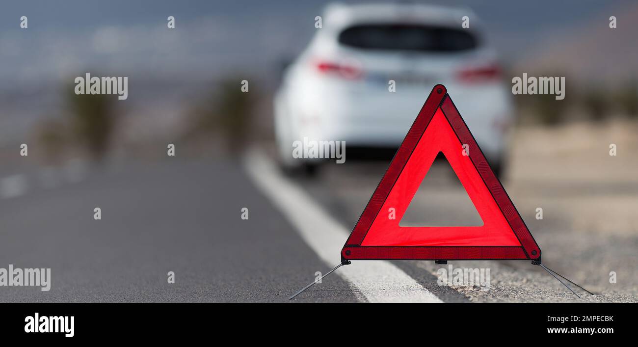 Broken down car with warning triangle behind it waiting for assistance ...