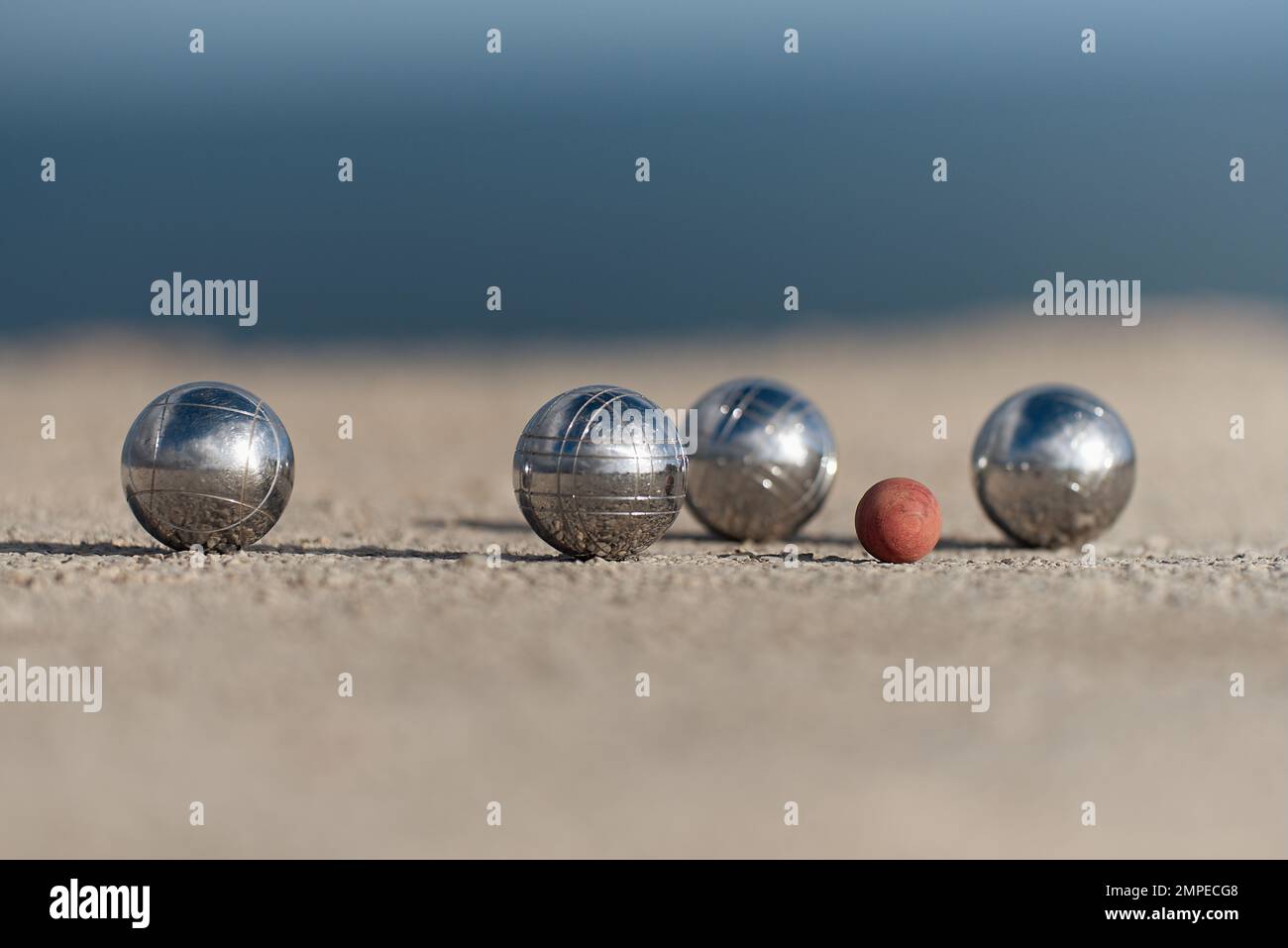Metallic petanque four balls and a small wood jack Stock Photo - Alamy