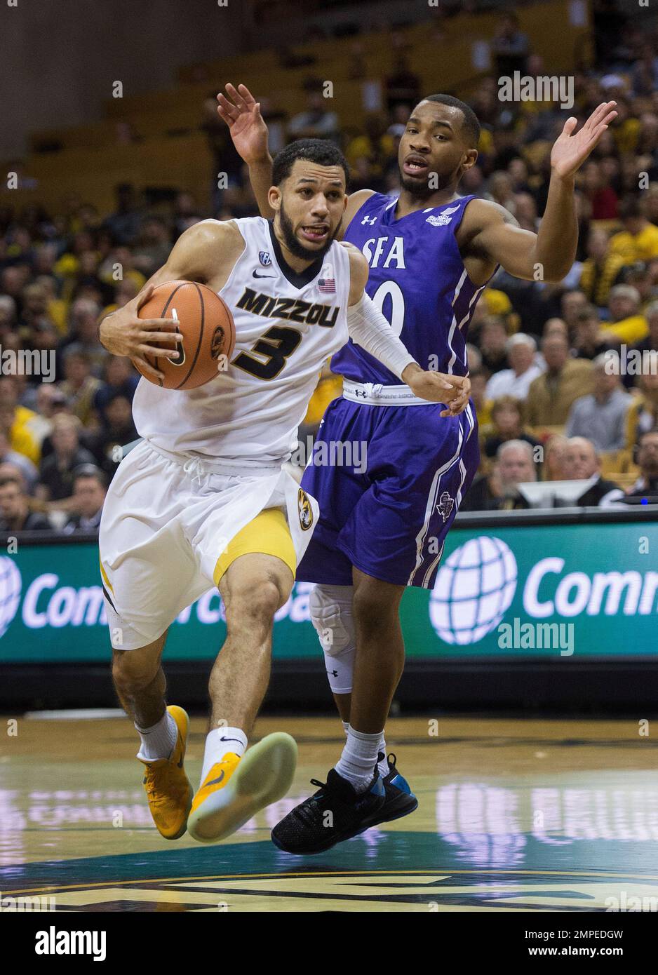 Missouri's Kassius Robertson, left, dribbles past Stephen F. Austin's ...